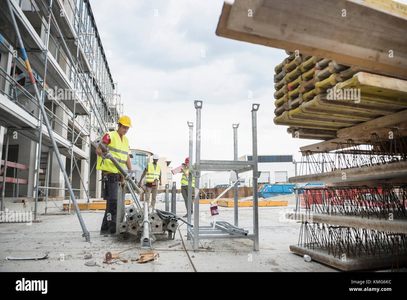 Construction workers working at building site Stock Photo - Alamy