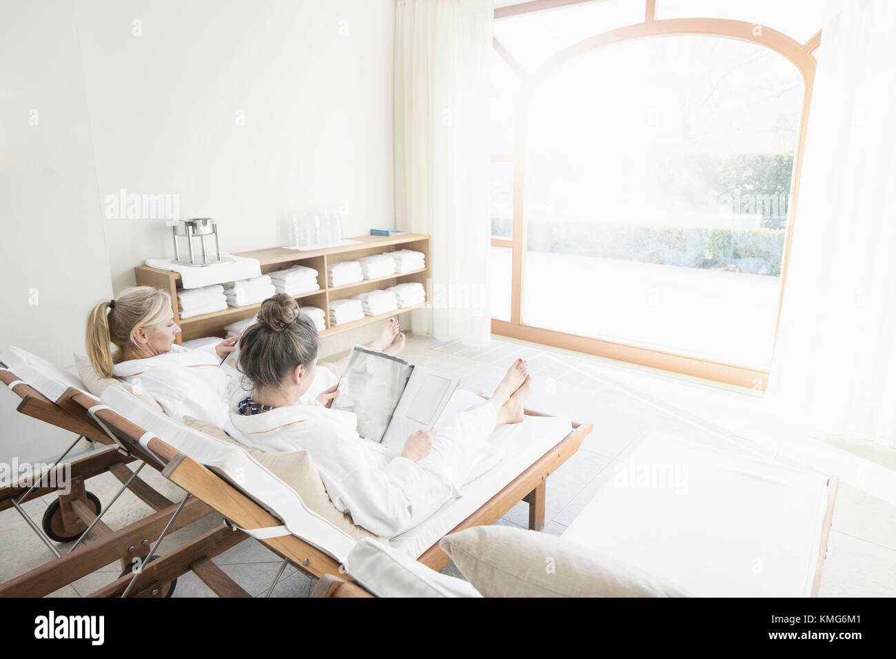 Women reading magazine while relaxing at spa Stock Photo - Alamy
