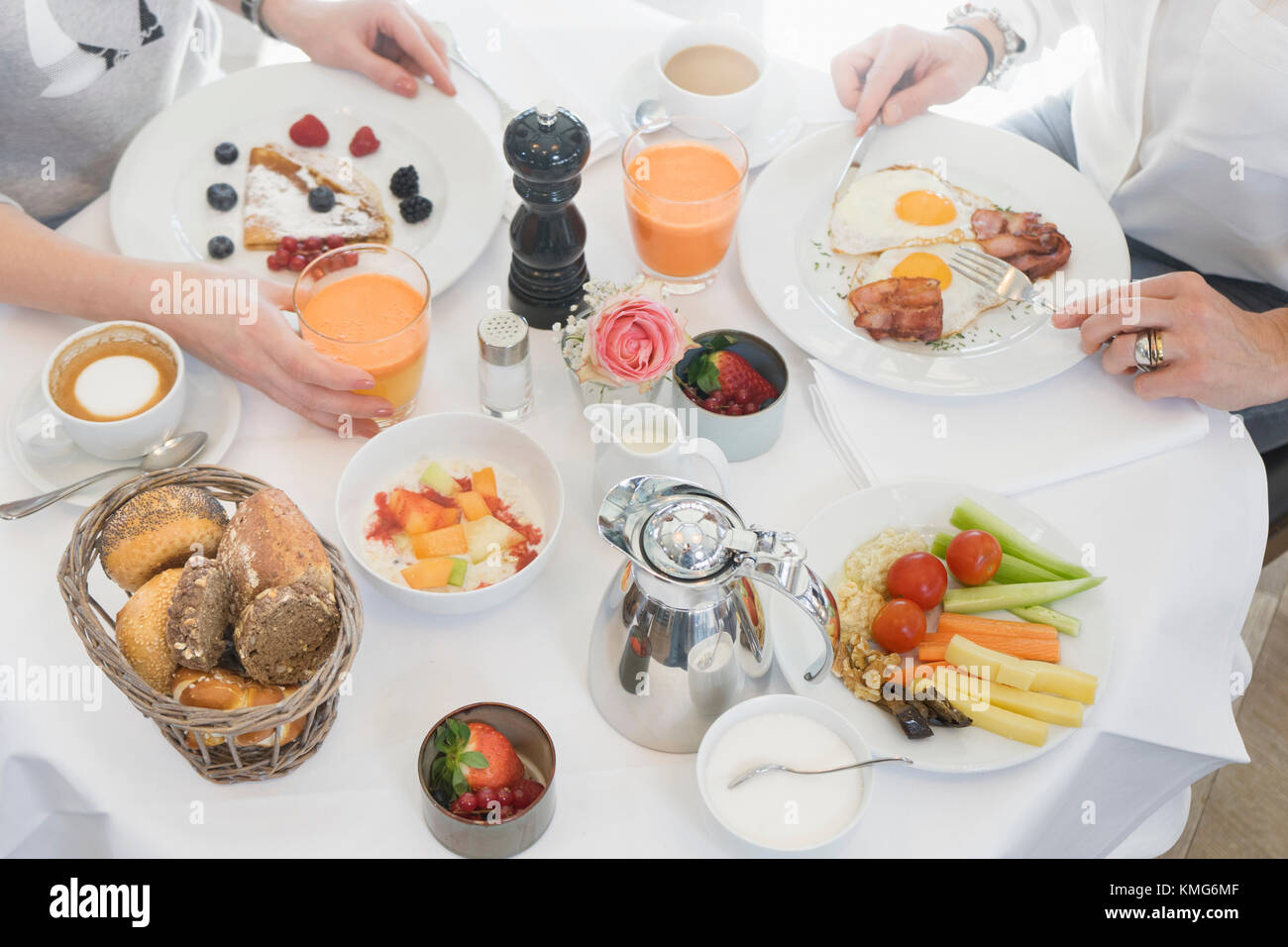 Women having breakfast on table Stock Photo - Alamy