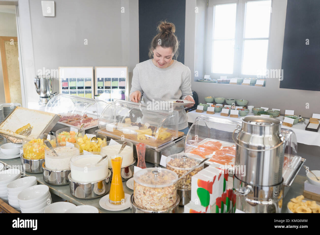 Woman taking cheese from breakfast buffet Stock Photo - Alamy