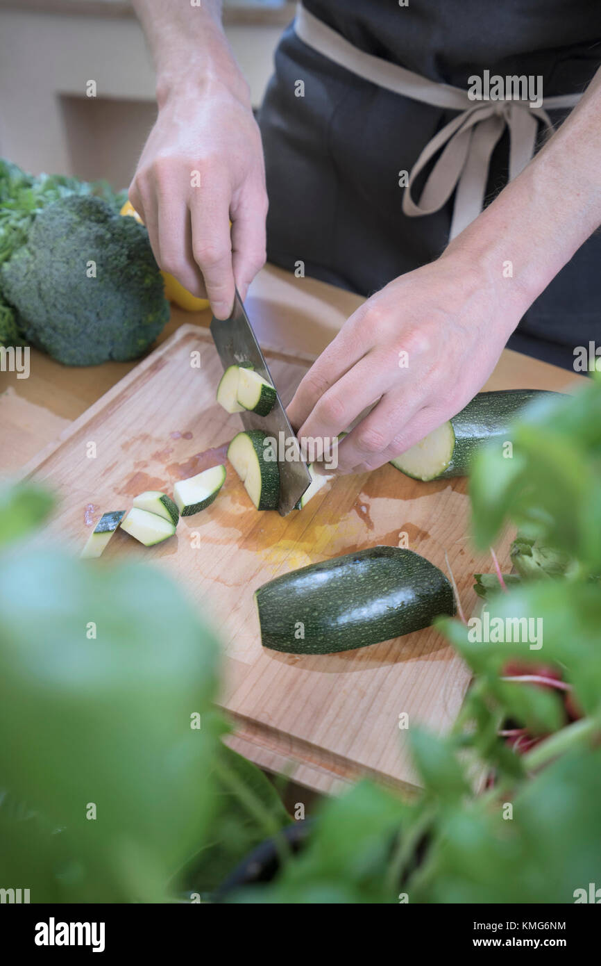 Man cutting zucchini and preparing food Stock Photo - Alamy