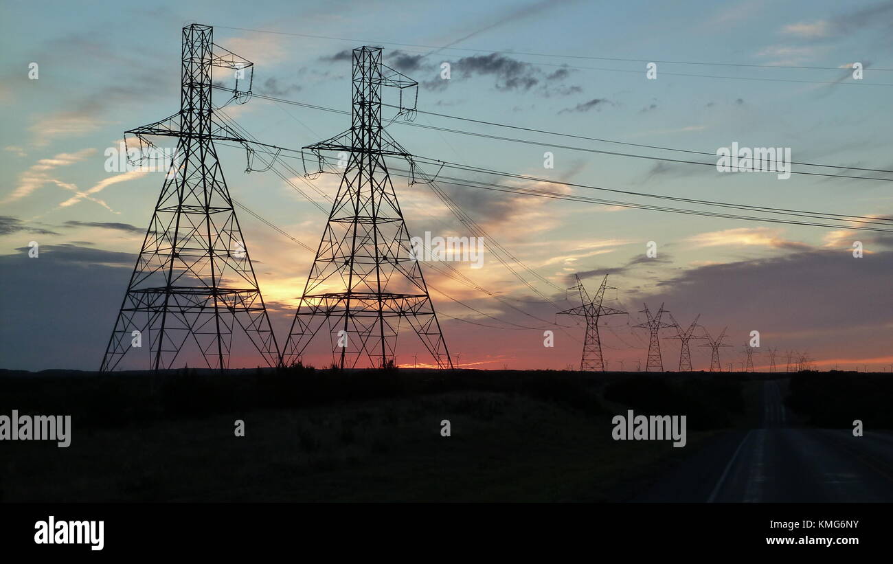 Long rows of large metal electrical towers at sunset, high voltage ...