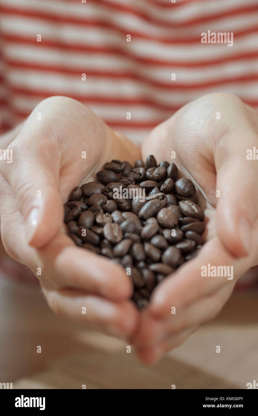 Hands full with coffee beans Stock Photo - Alamy