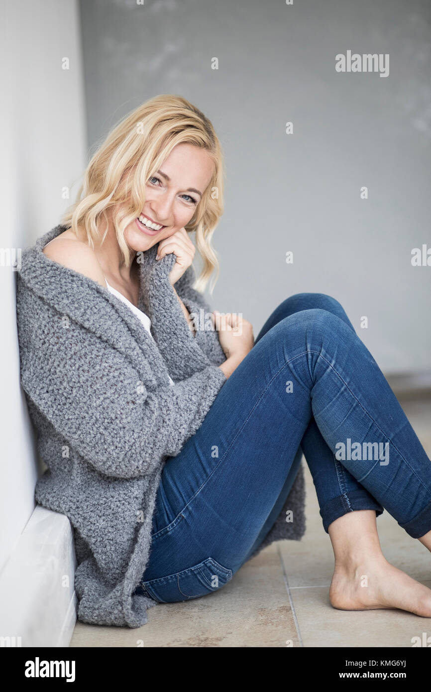 Portrait of fashion model sitting on floor Stock Photo - Alamy
