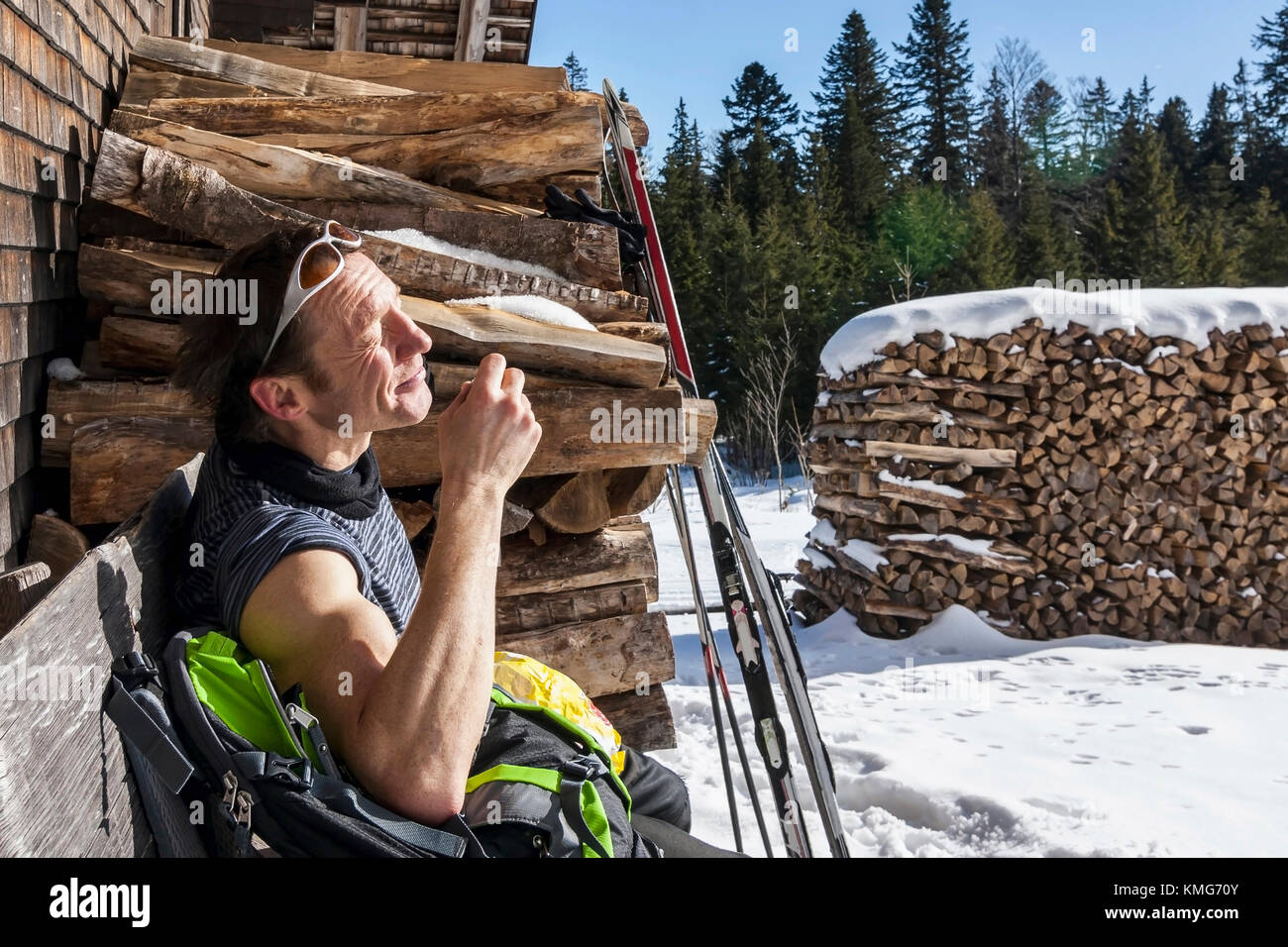 Man Taking rest on bench in front of a log cabin Stock Photo - Alamy