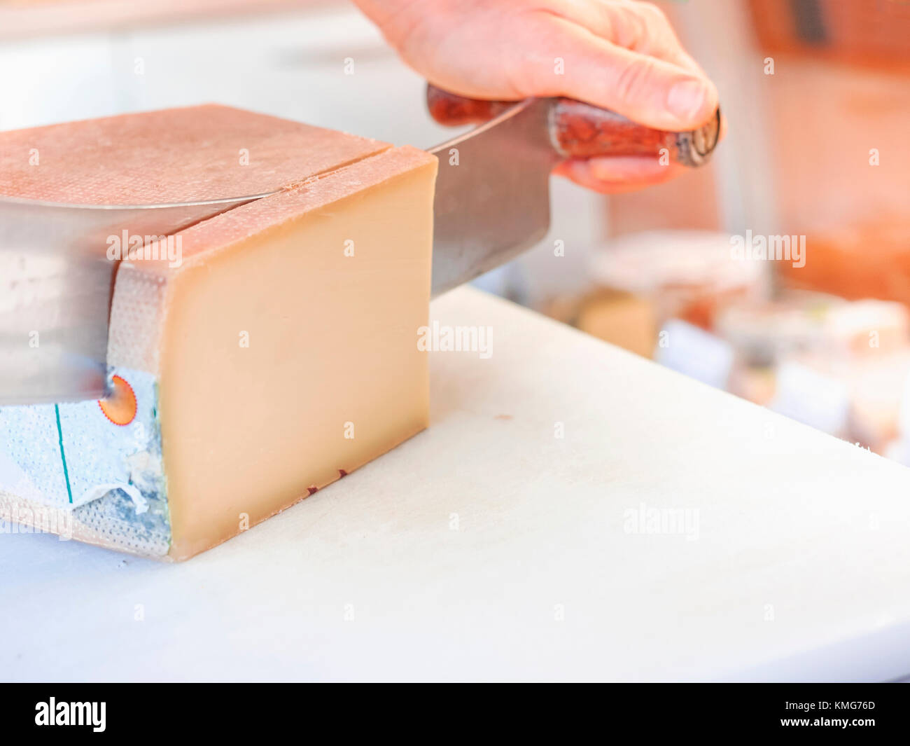 Woman cutting French Comte cheese Stock Photo - Alamy