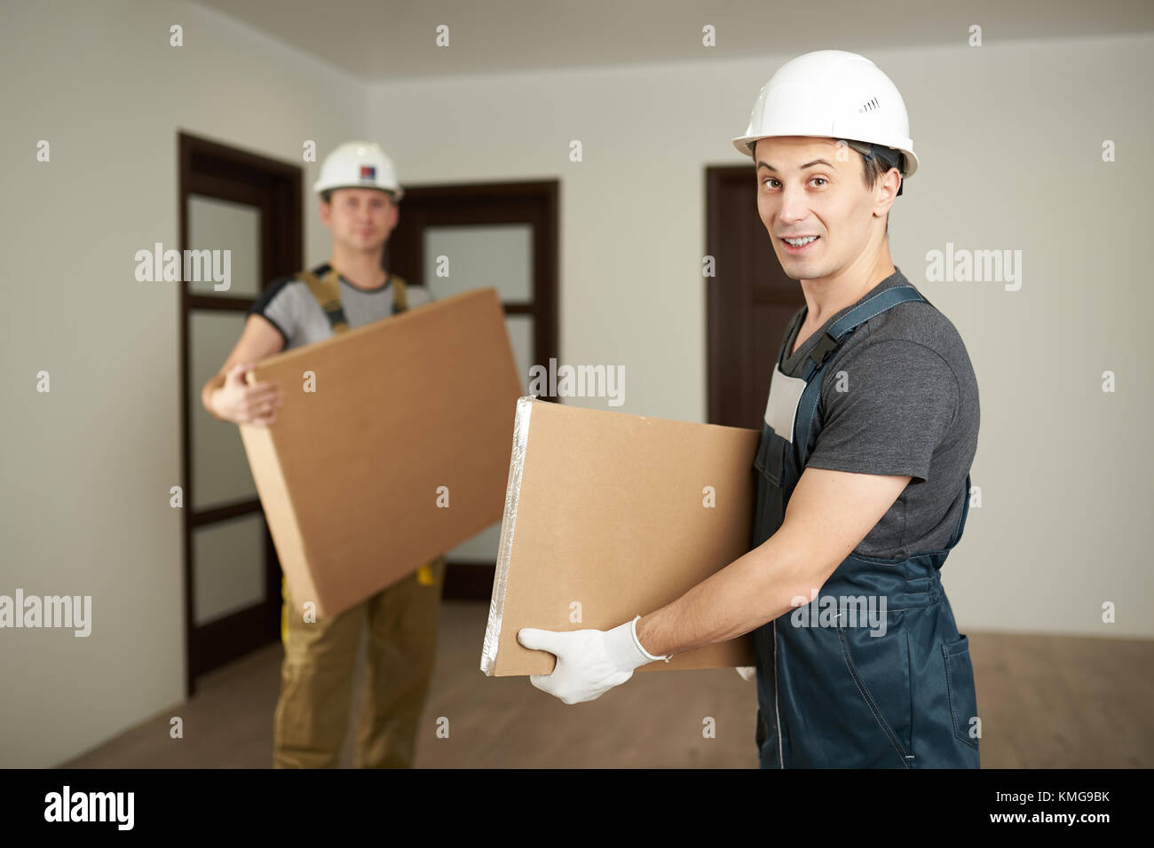 Delivery parcel concept. Two man hold cardboard boxes Stock Photo - Alamy