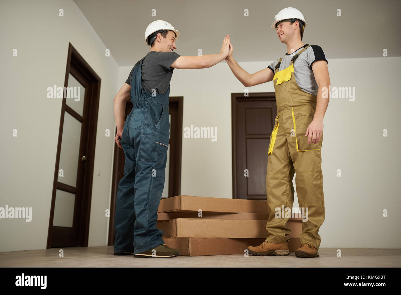 Two workers give high five in successful job Stock Photo - Alamy