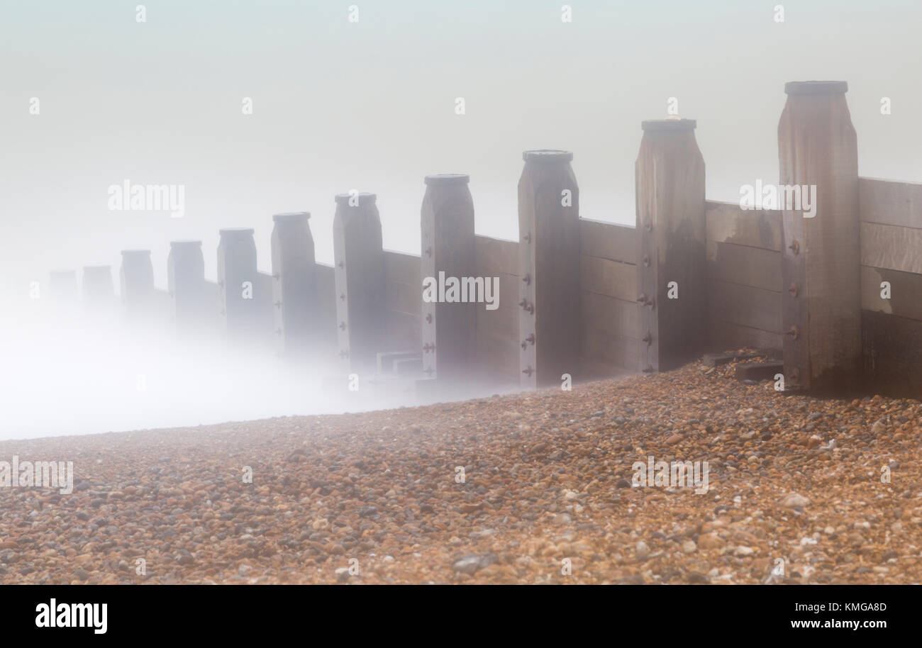 Groynes on the beach at the seaside with sea and waves at Shoreham ...
