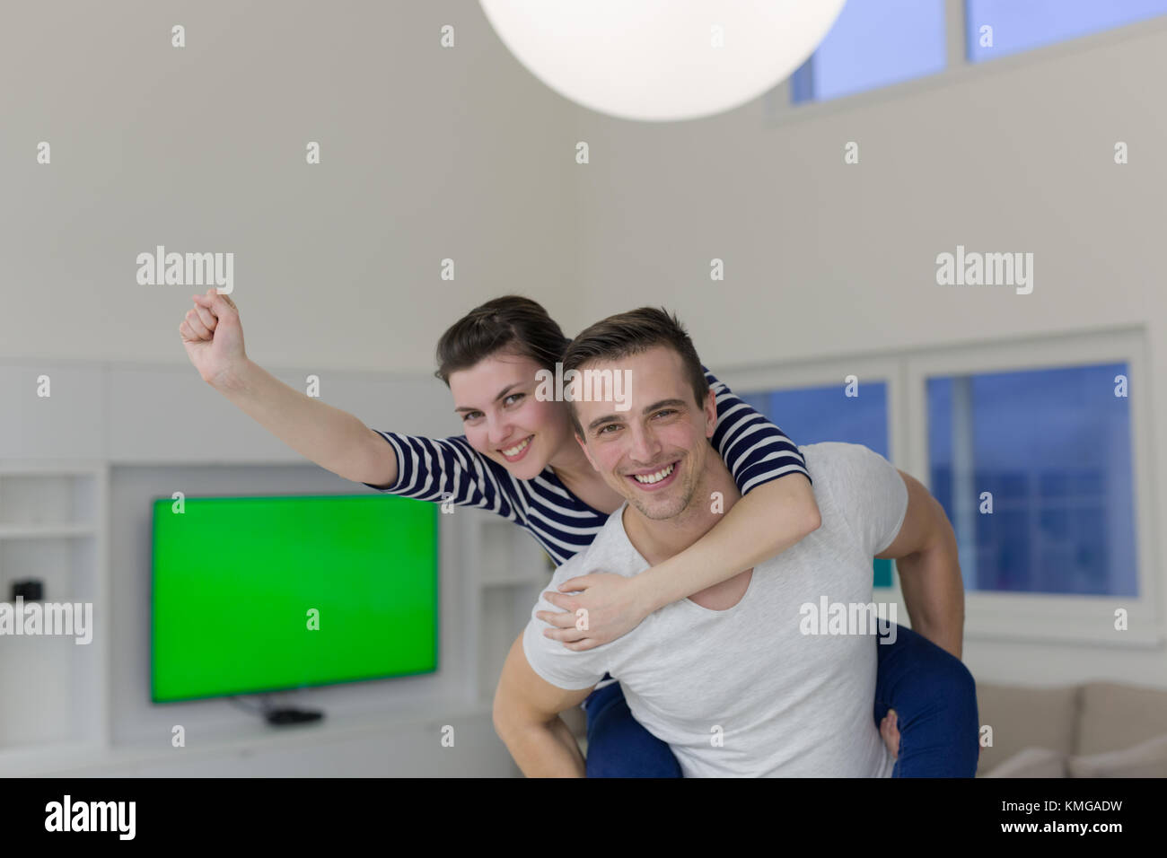 happy young man piggybacking his girlfriend at home Stock Photo - Alamy