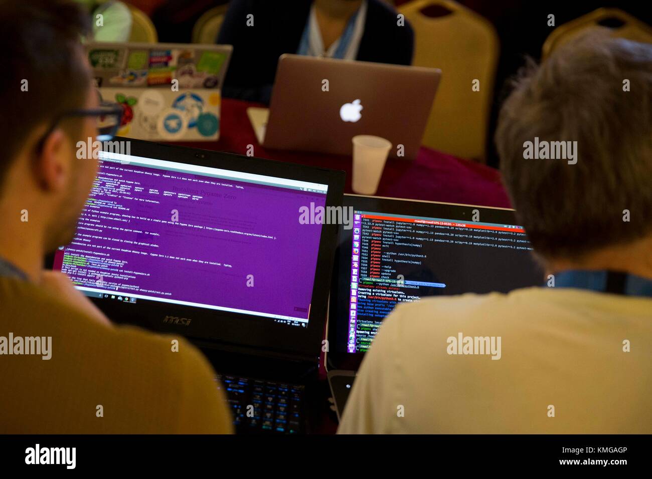 Coders on laptop screens at a conference Stock Photo - Alamy