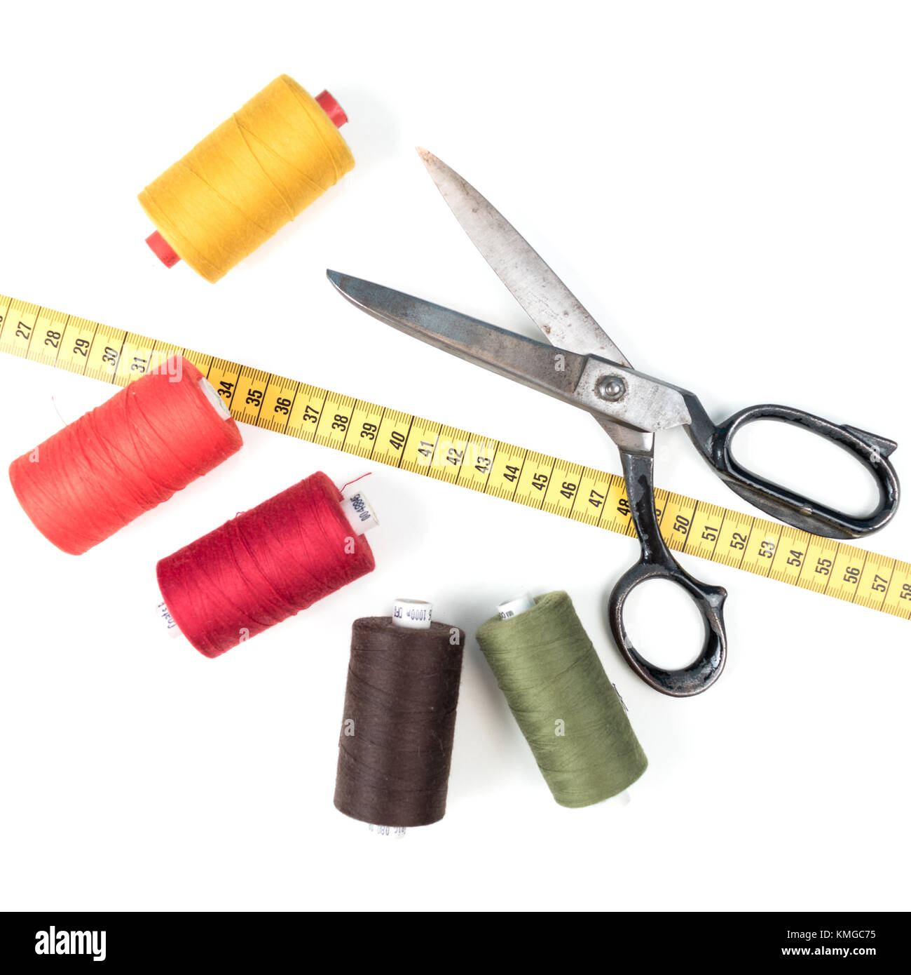 Sewing thread coil with old metal scissors and yellow measuring tape on ...