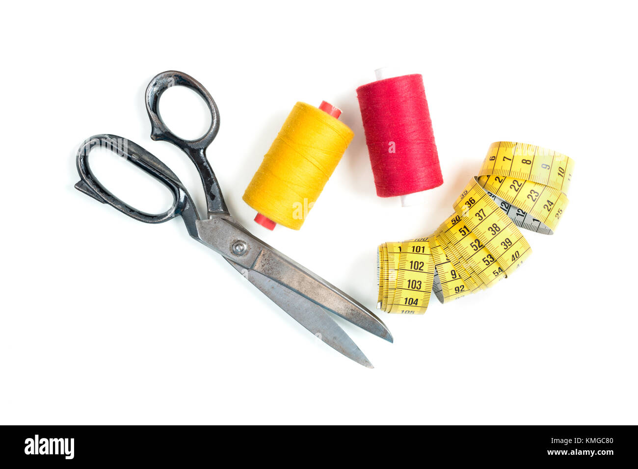 Sewing thread coil with old metal scissors and yellow measuring tape on ...