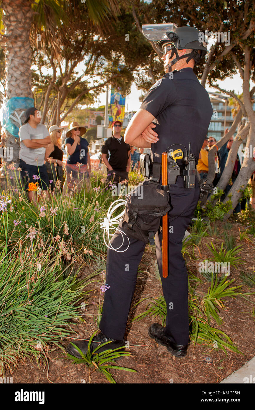 Ready to make arrests, a police officer wearing a hard hat brings a ...