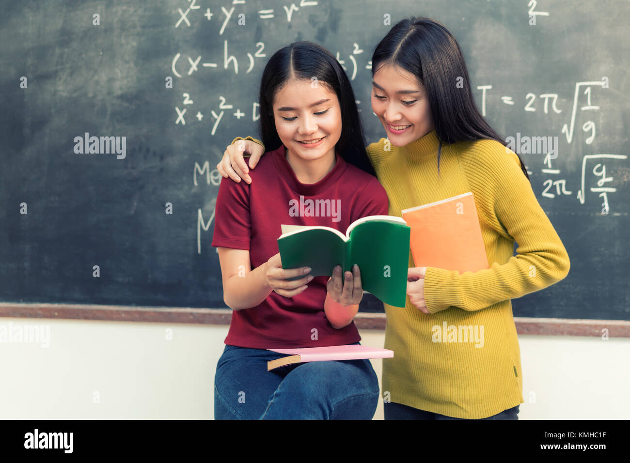 Two Asian students studying together in classroom at university ...
