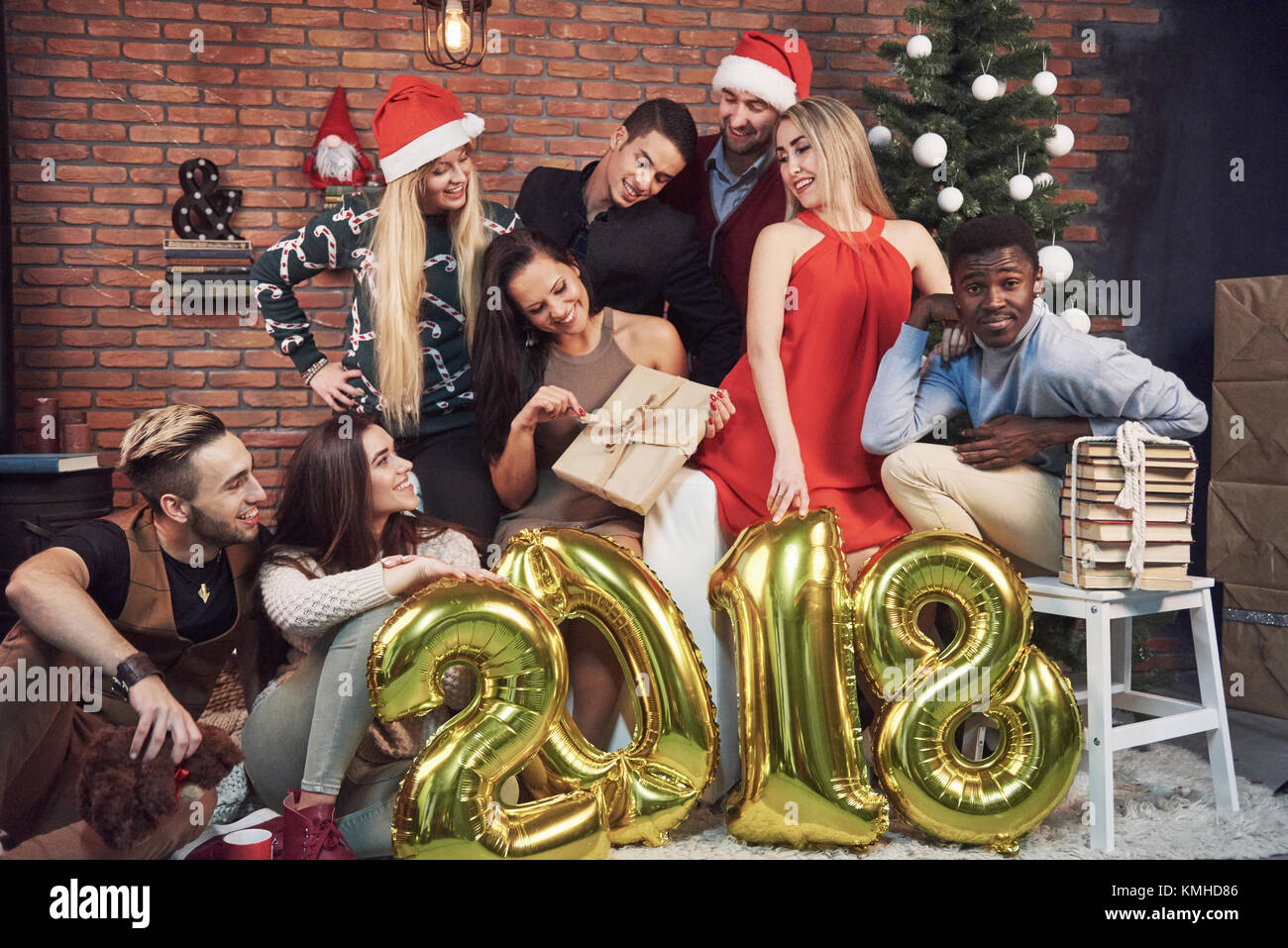 Group of cheerful old friends have made a gift to a girl. New 2018 Year ...