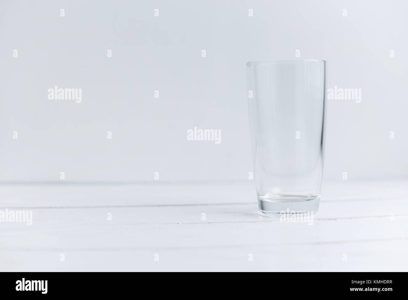 Close up view of empty glass standing on white wooden table Stock Photo ...