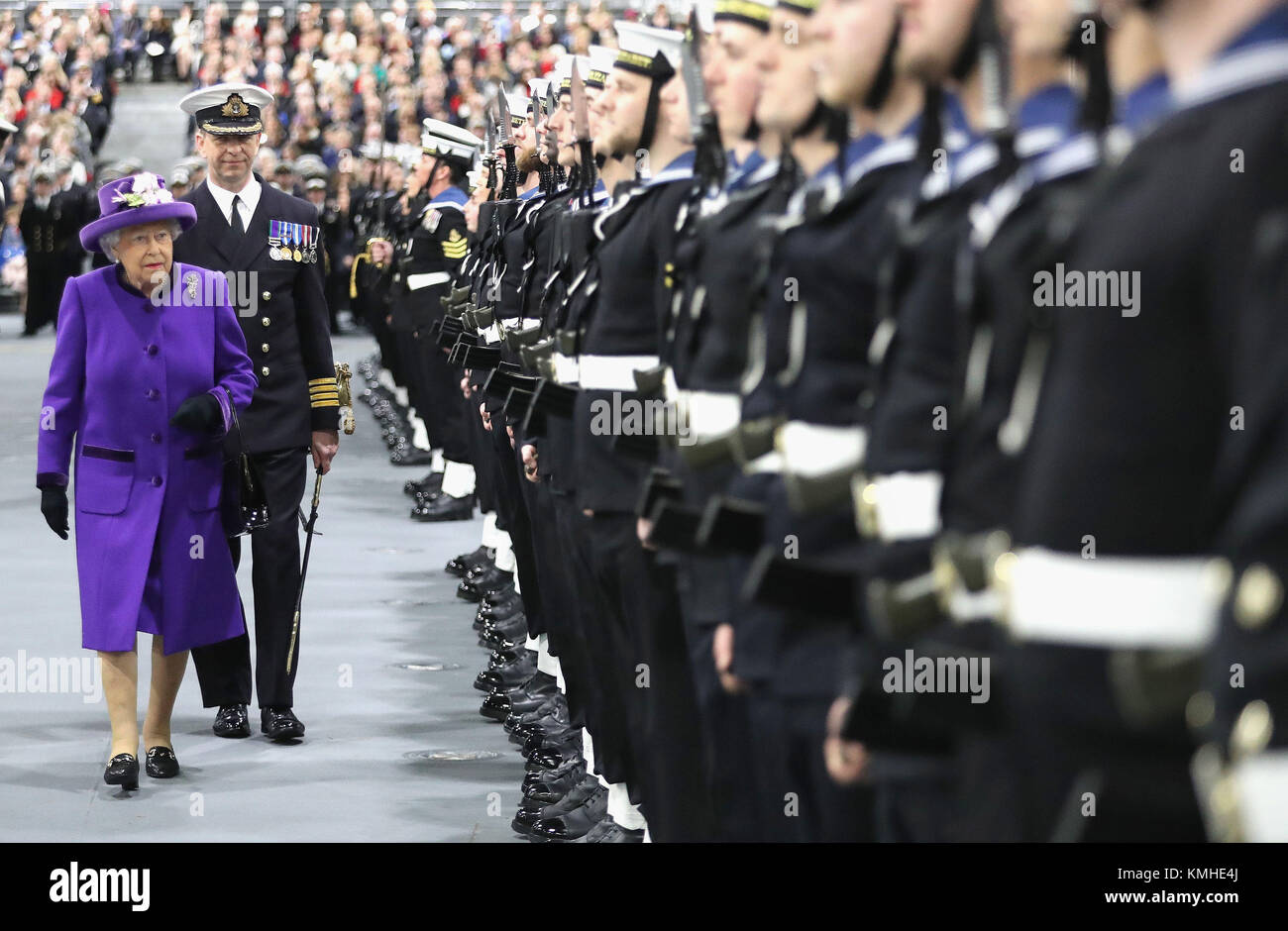 Queen Elizabeth II walks with the ships Captain, Commodore Jerry Kyd ...