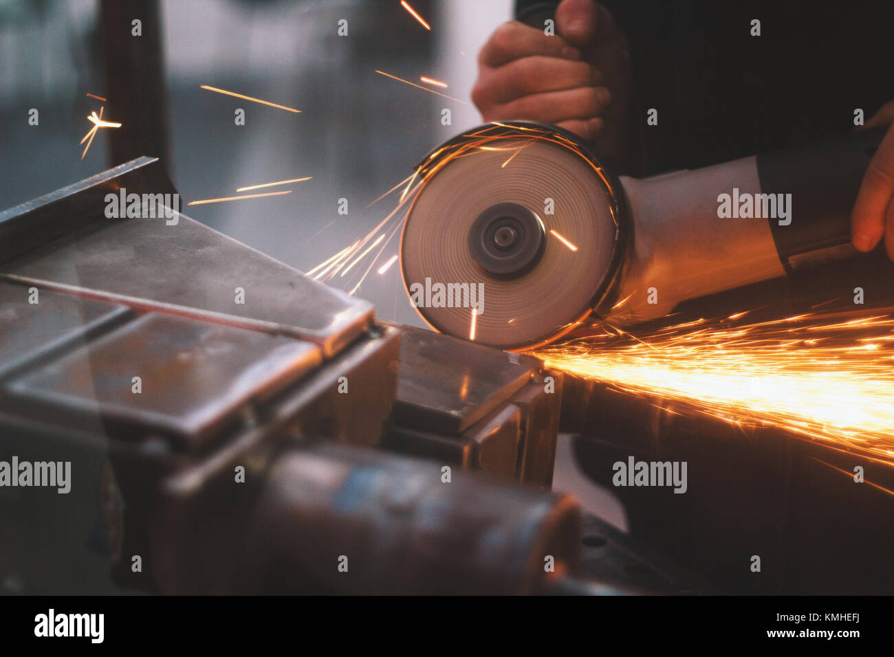 Metal workshop - worker grinding metal construction with a circular saw ...