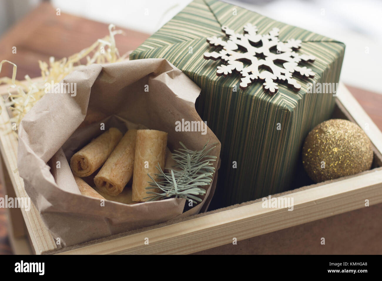 A festive still life with a big wooden box with presents and cookies ...