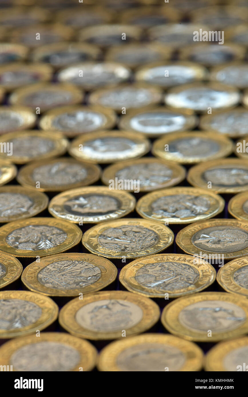 a large number or a lot of one pound coins laid flat on a large surface ...