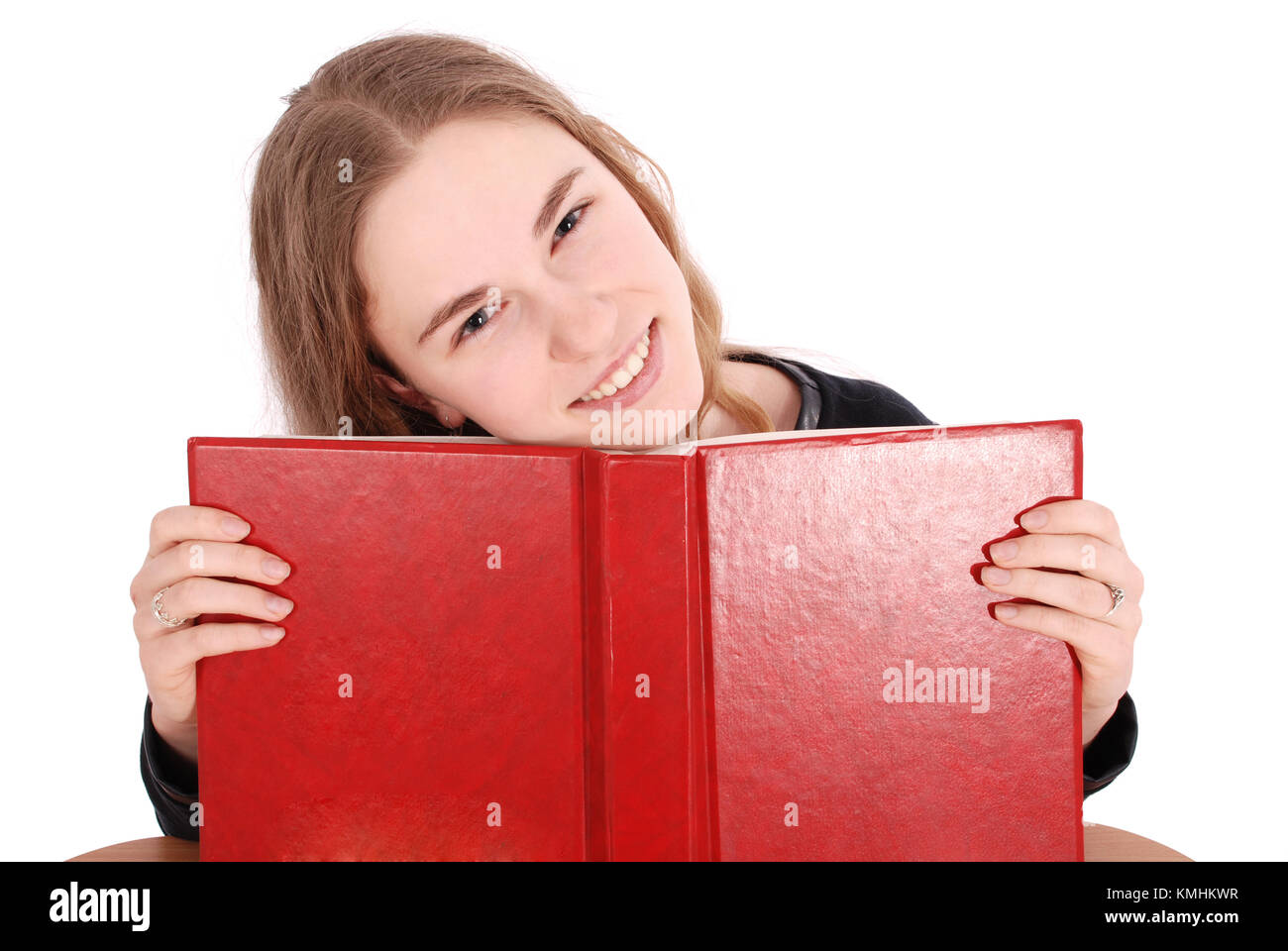Beautiful school girl peeping from behind her red book isolated on ...