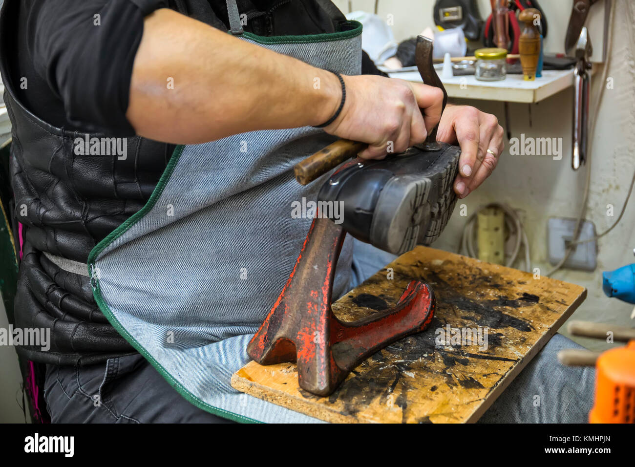 Shoemaker repairing a shoe sole in workshop. Selective focus. Vintage ...