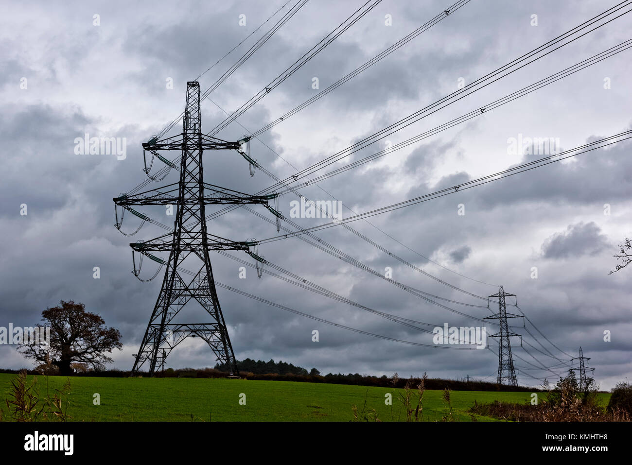 Overhead electricity cables and large pylons across open countryside ...