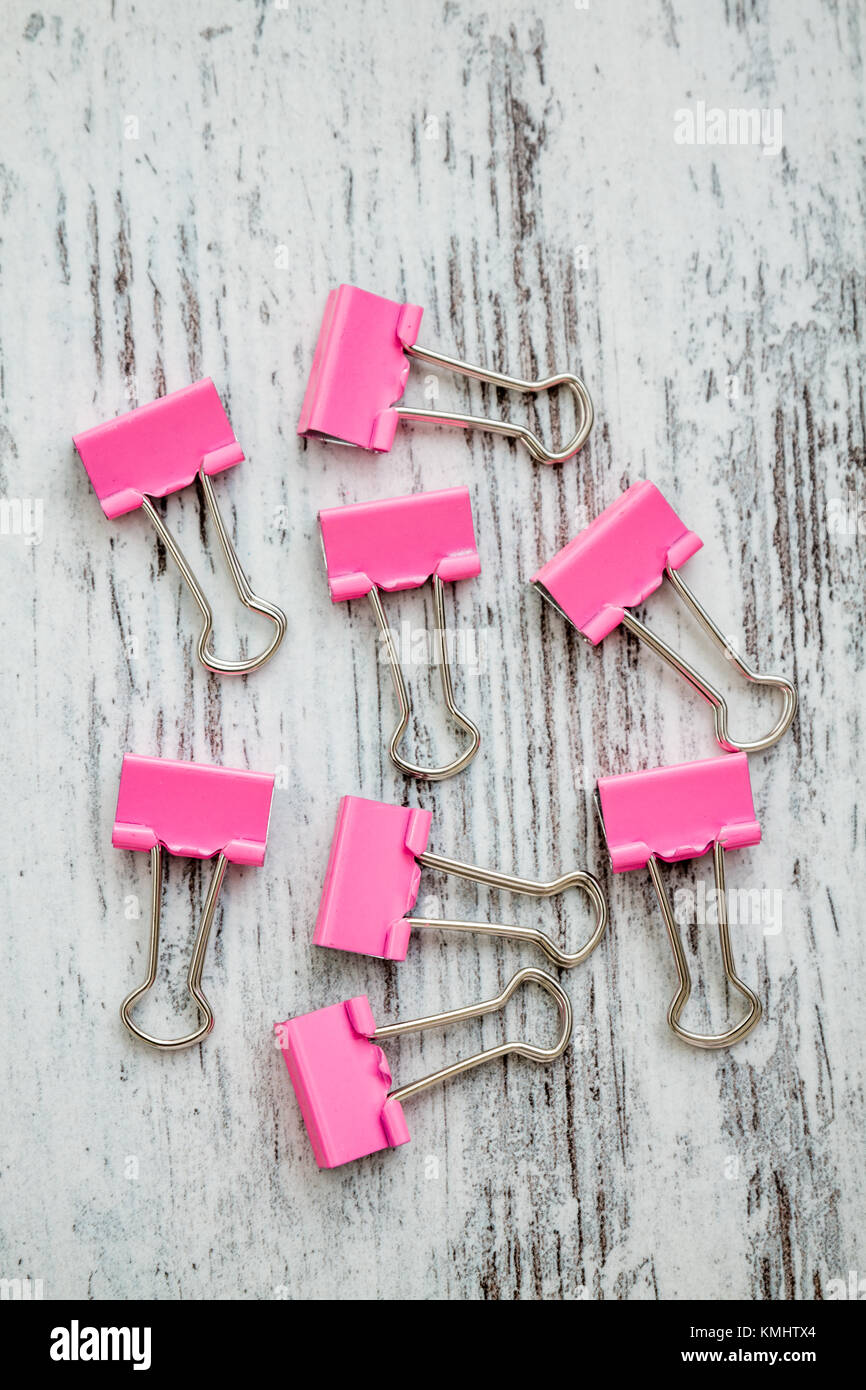 Pink binder paper clips on white wooden background Stock Photo - Alamy