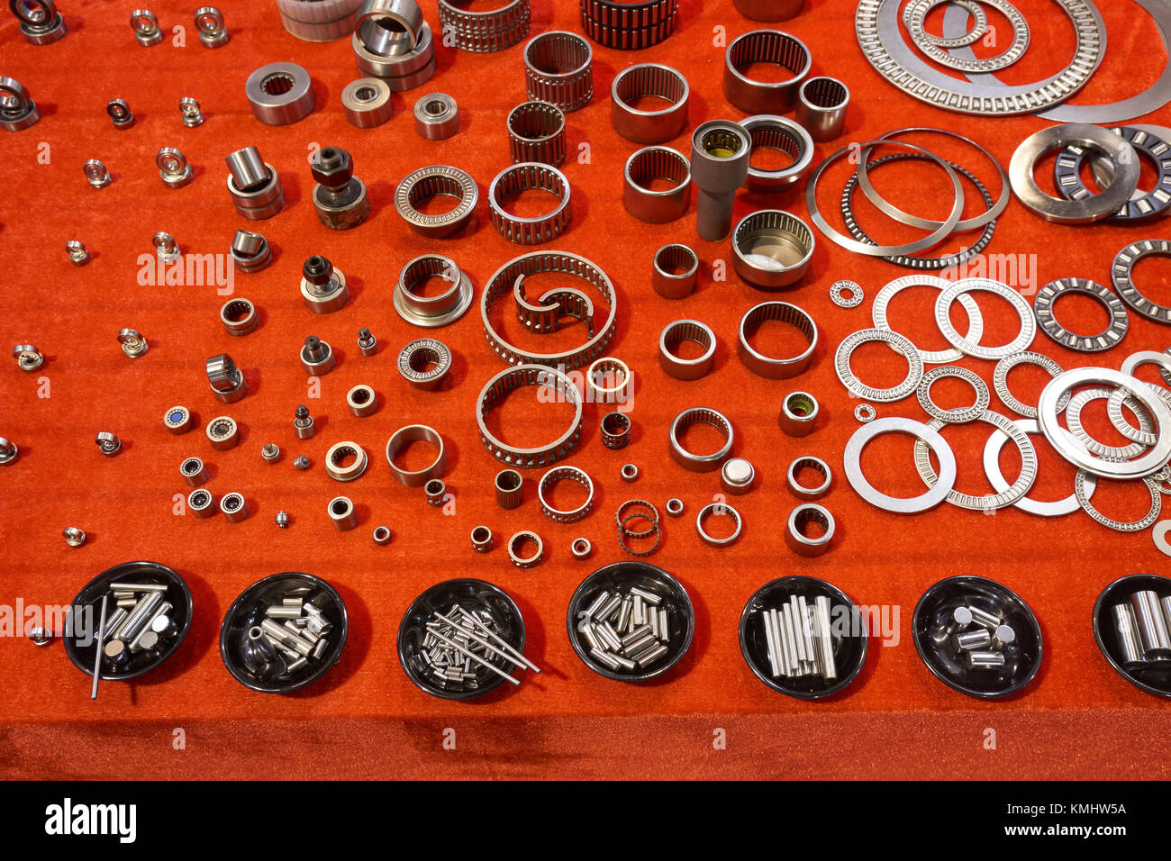Variety of bearings and components on red table Stock Photo - Alamy