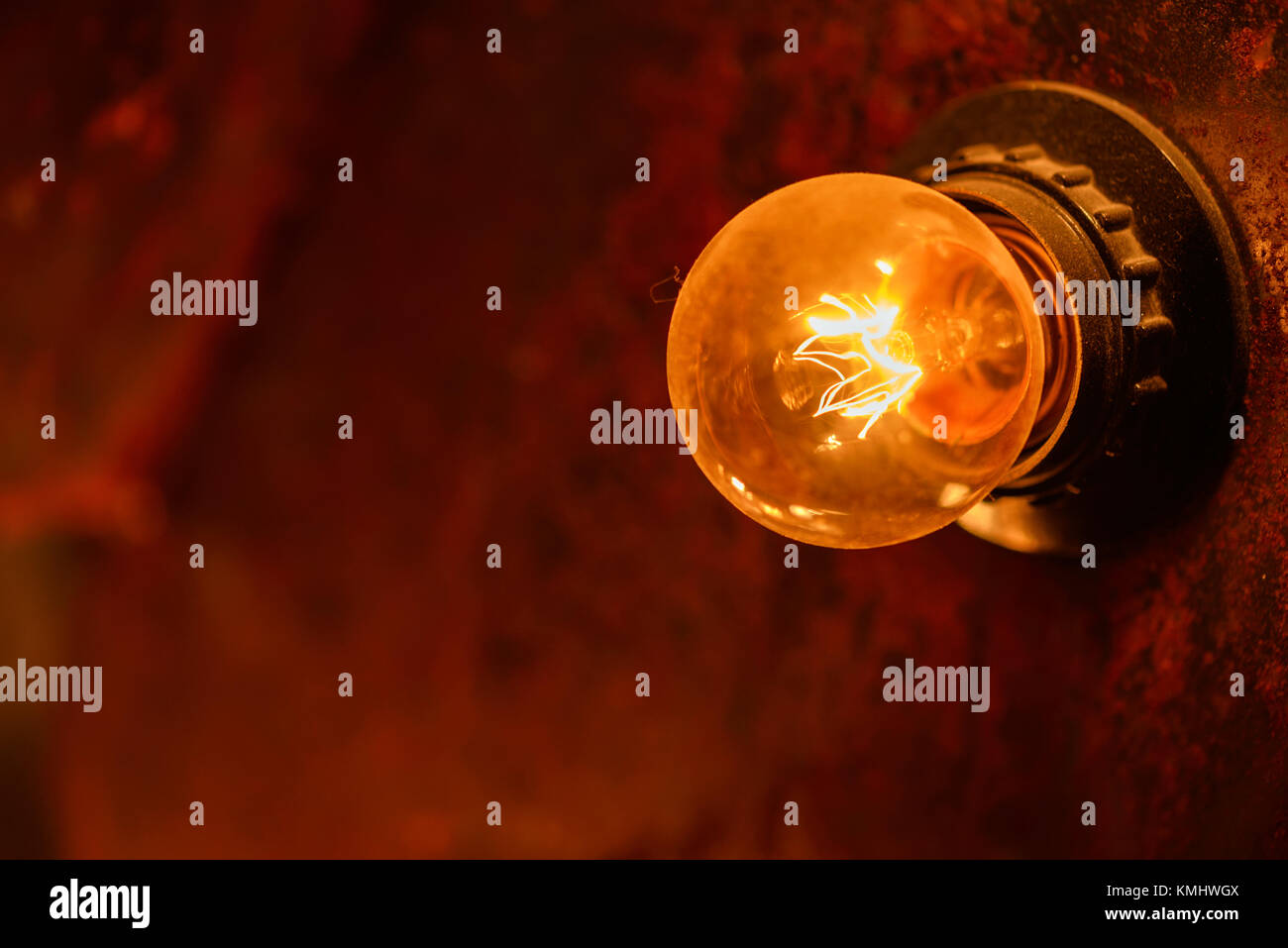 Burning light bulb on the wall Stock Photo - Alamy