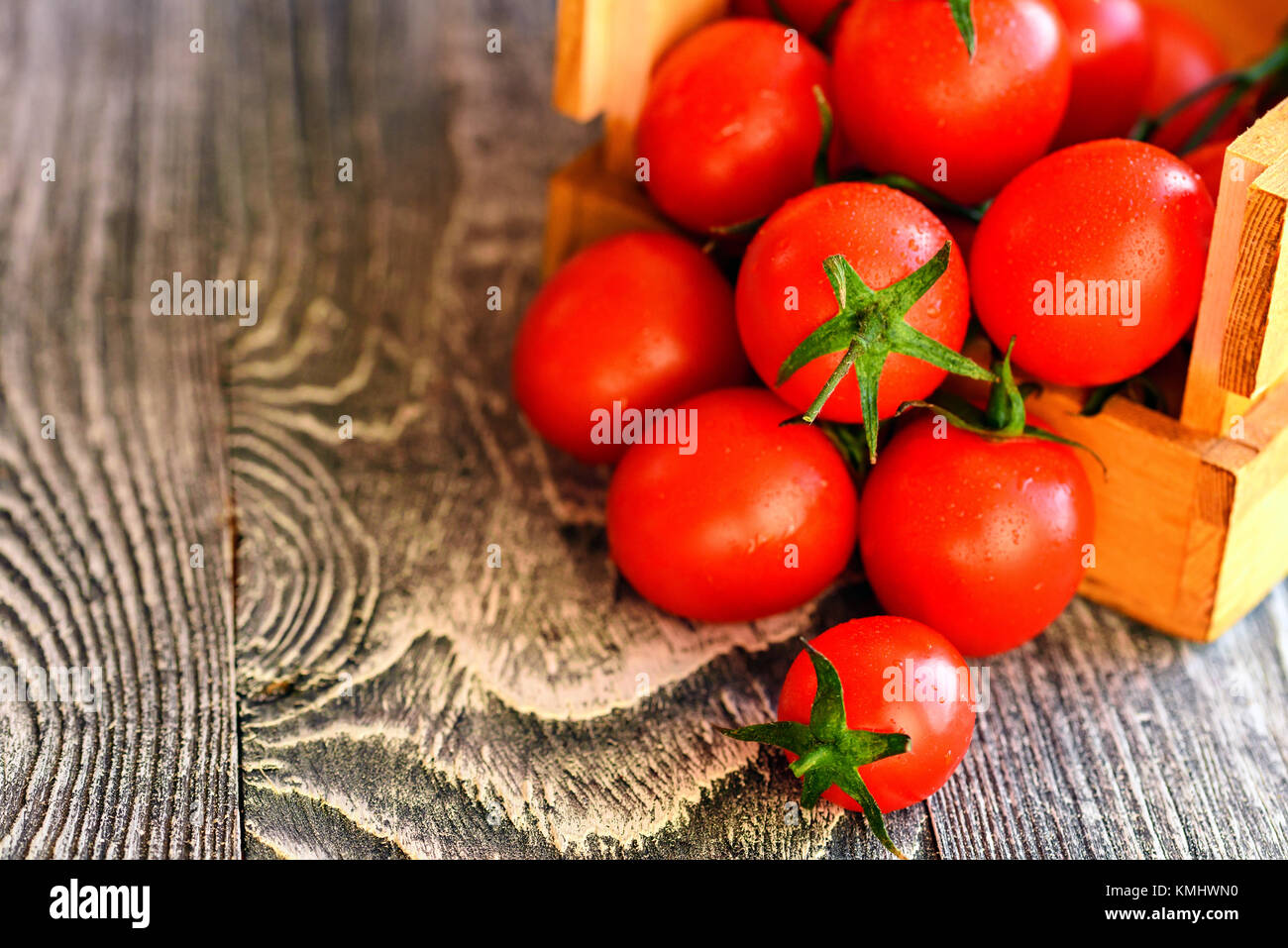 Red ripe tomatoes spill out of box. Rustic view Stock Photo - Alamy