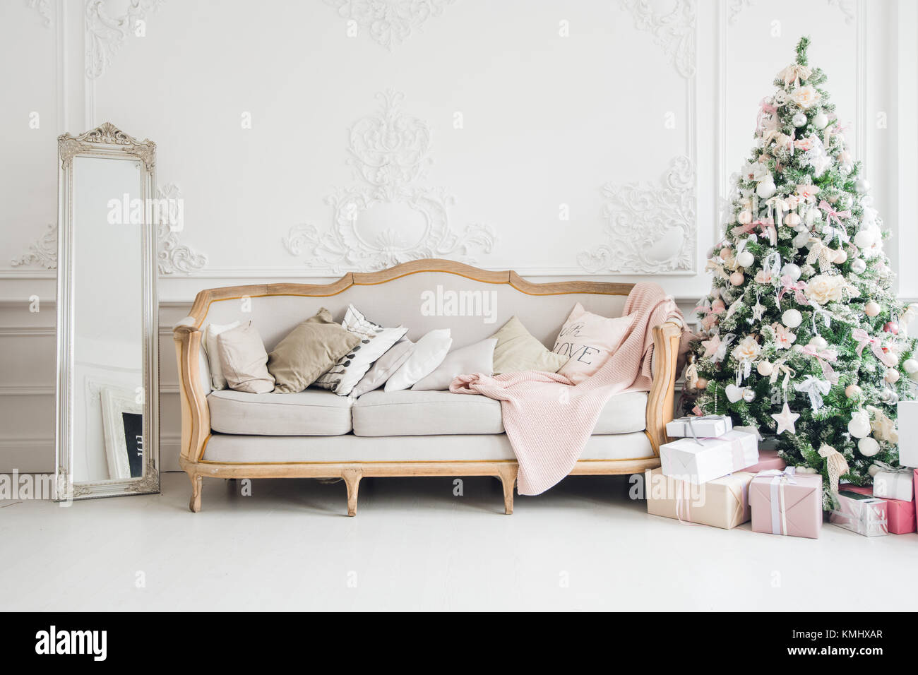 Christmas tree with a white sofa in a white room Stock Photo - Alamy