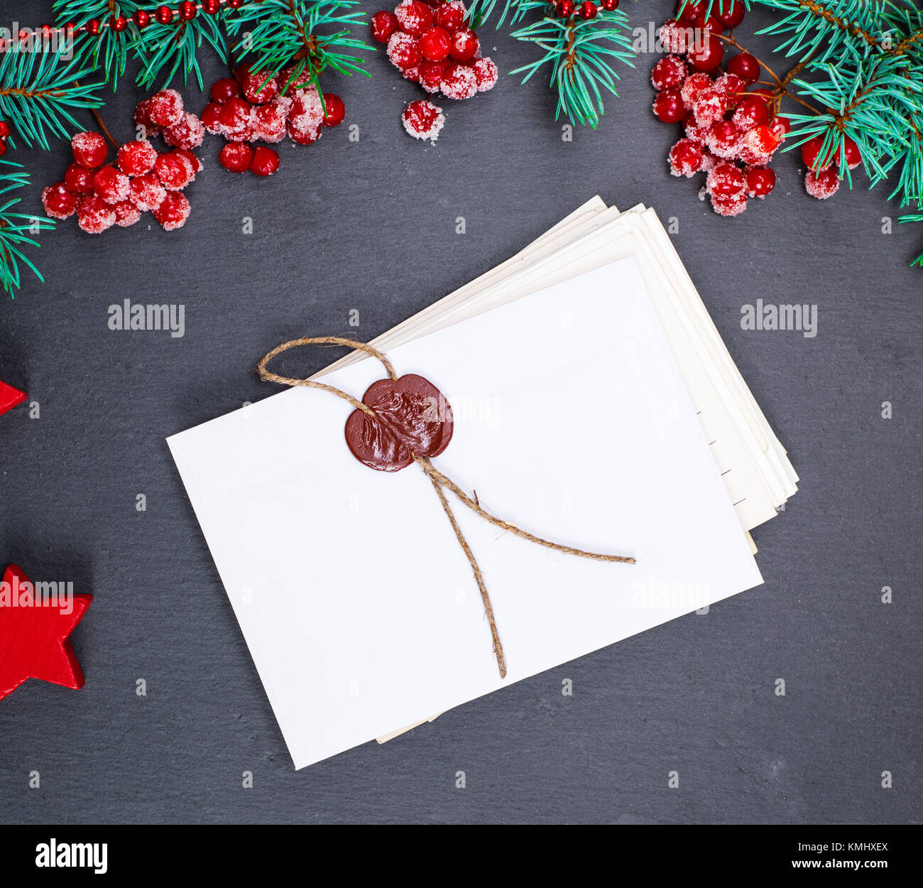 empty white paper covert sealed and green spruce branches on a black ...