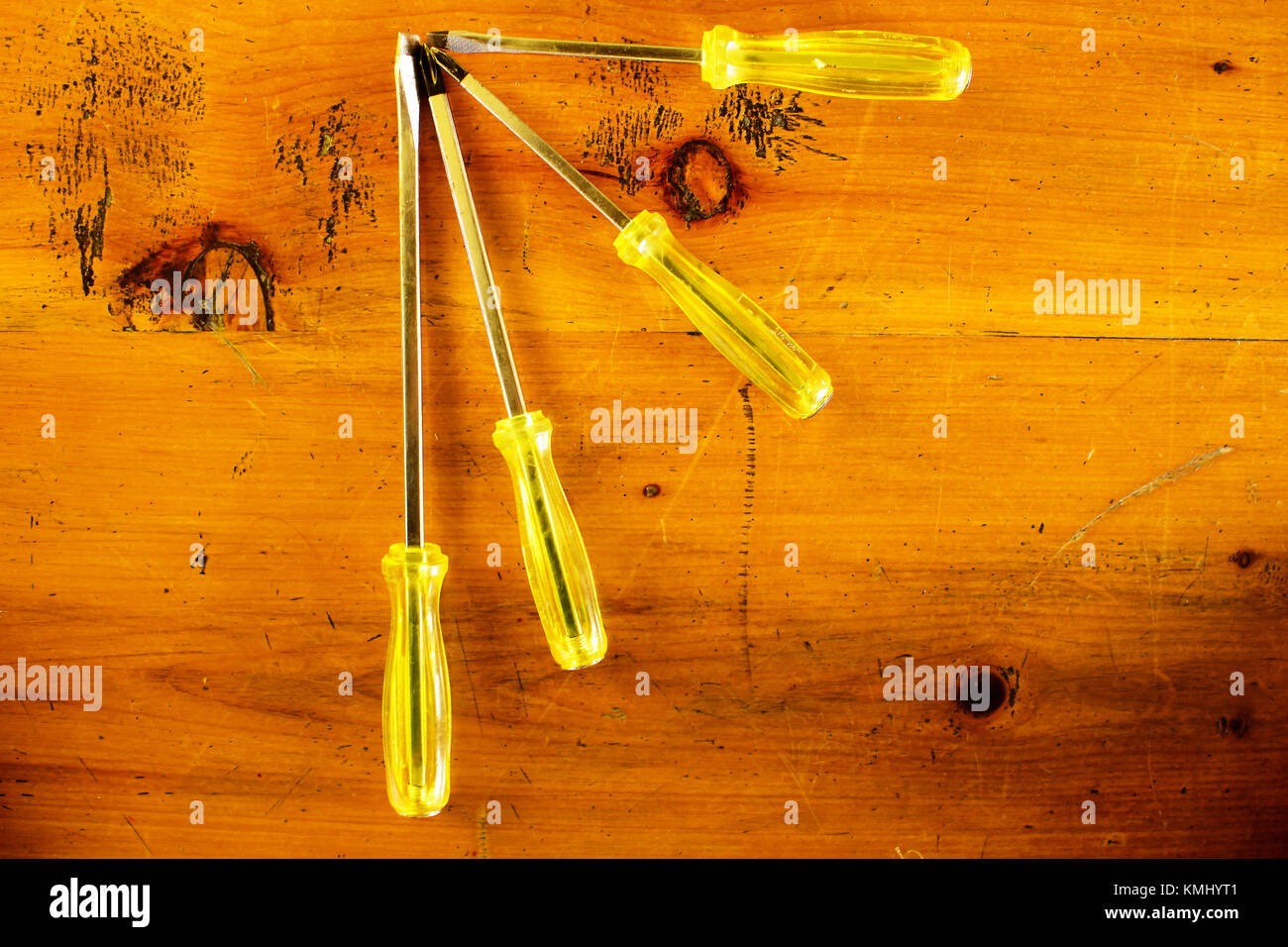 Horizontal photo of a yellow screwdrivers set on wood table viewed from ...