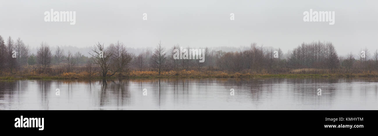 Panorama of autumn river landscape. Snowfall, cloudy weather. Overcast ...