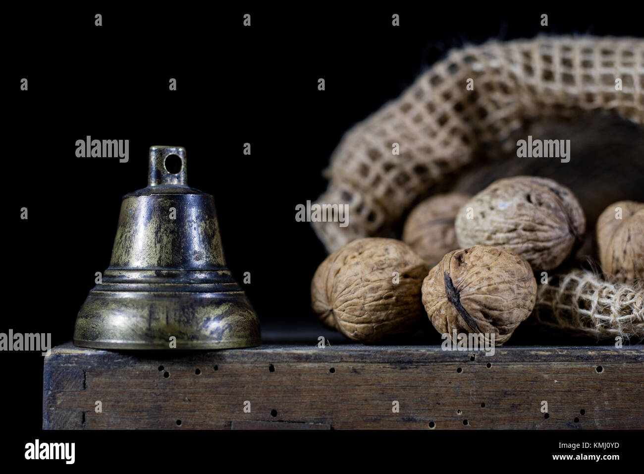 Nuts in a natural bag. A bag of nuts and a bell on an old dark wooden ...