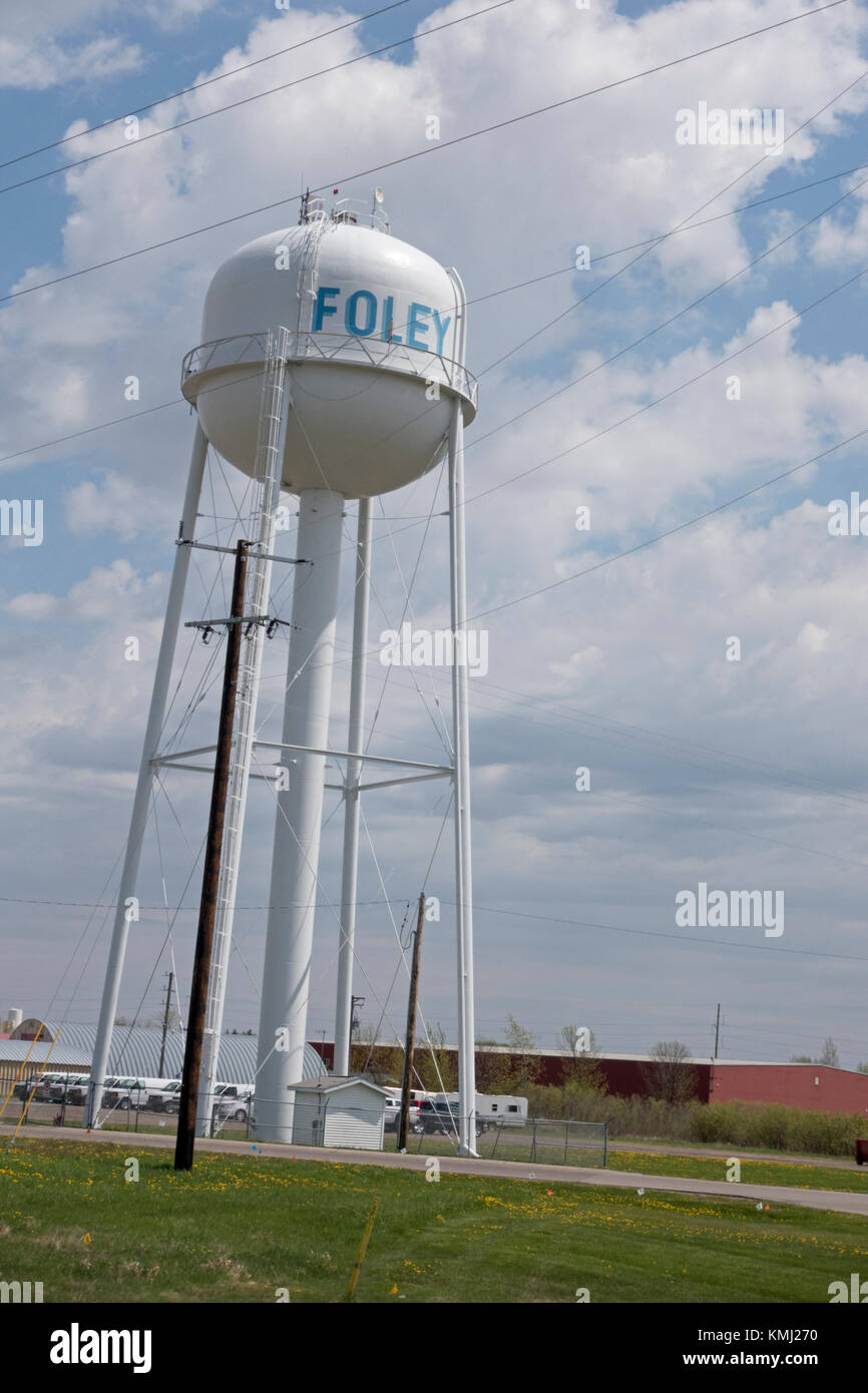 City water tower with blue sky filled with puffy clouds and surrounded ...