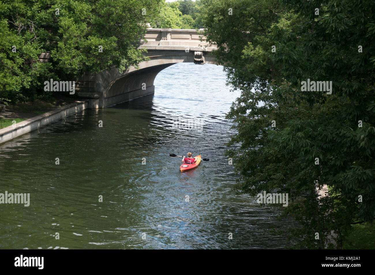 Young woman paddling her kayak in the channel from Lake Calhoun into ...