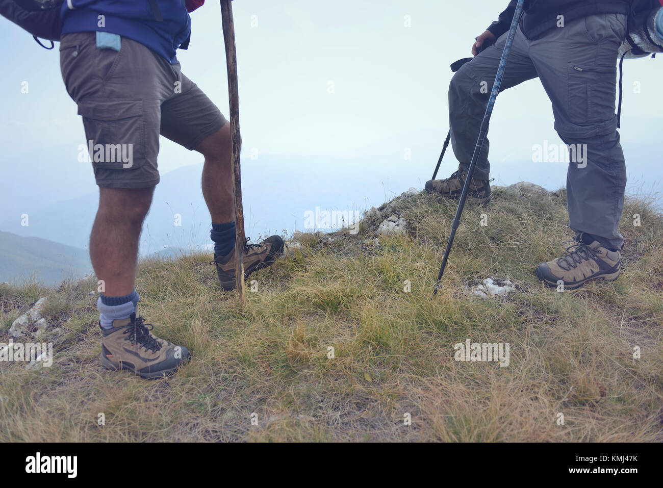 Close-up of legs of young hikers walking on the country path. Young ...