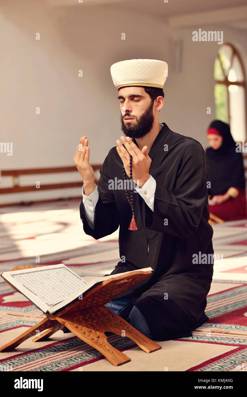Muslim man and woman praying for Allah in the mosque together Stock ...