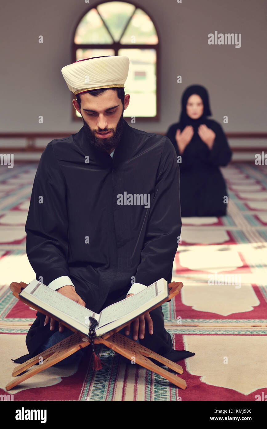 Muslim man and woman praying for Allah in the mosque together Stock ...
