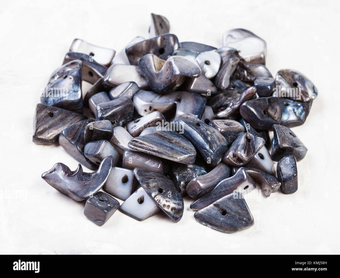 pile of beads from natural nacre stones on gray concrete background ...