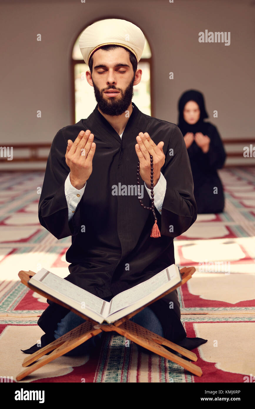 Muslim man and woman praying for Allah in the mosque together Stock ...