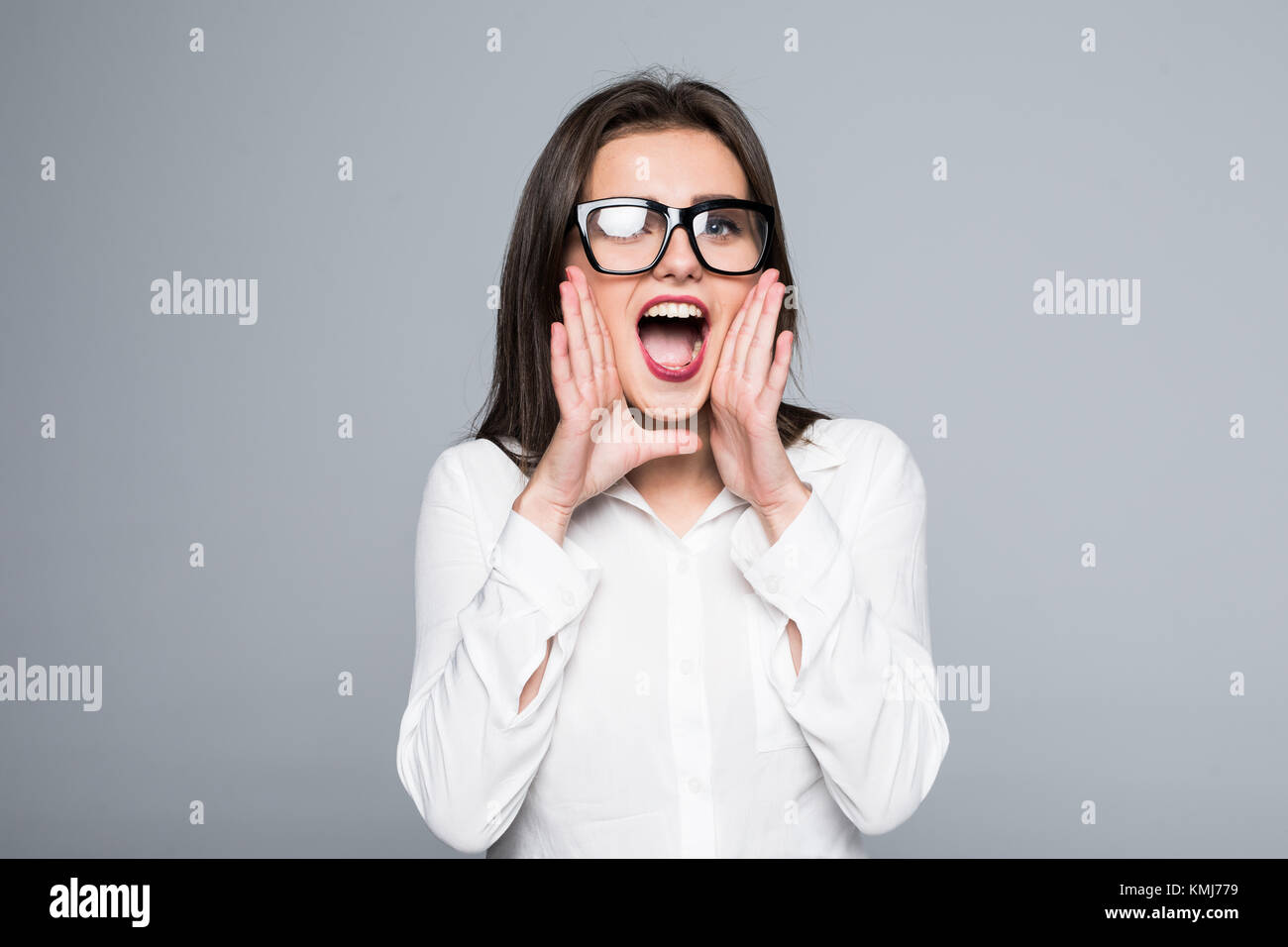 Young woman screaming loudly isolated on gray Stock Photo - Alamy
