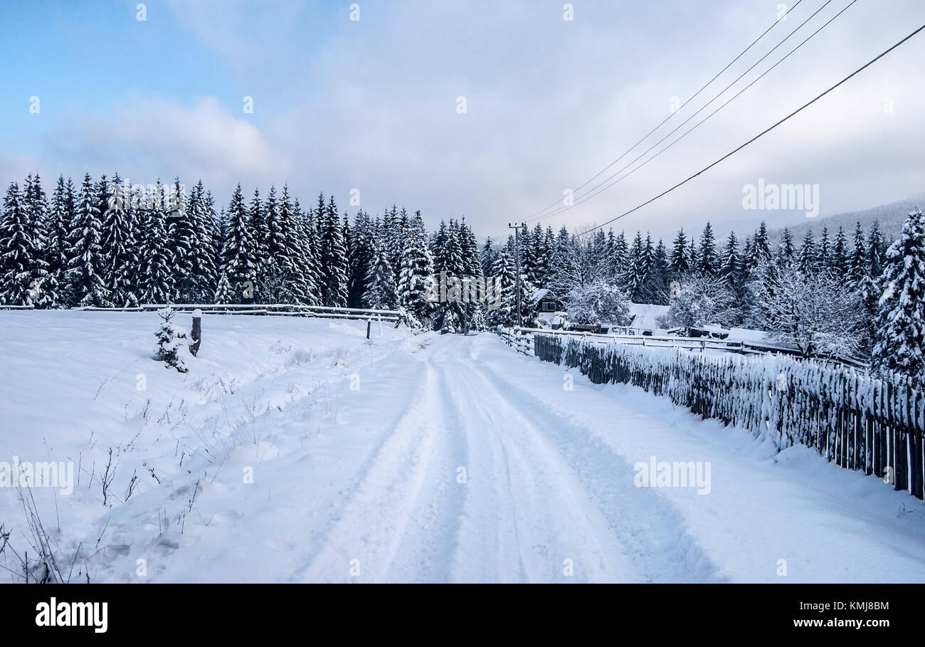 winter countryside with snow covered road, isolated house with fence ...