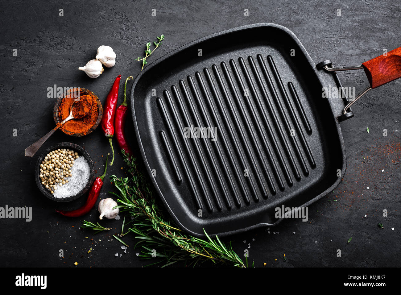 Empty cast-iron grill pan with ingredients for cooking on black ...