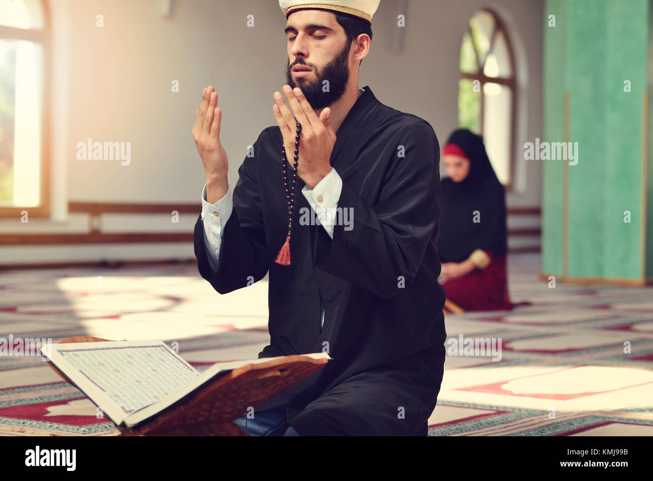 Muslim man and woman praying for Allah in the mosque together Stock ...