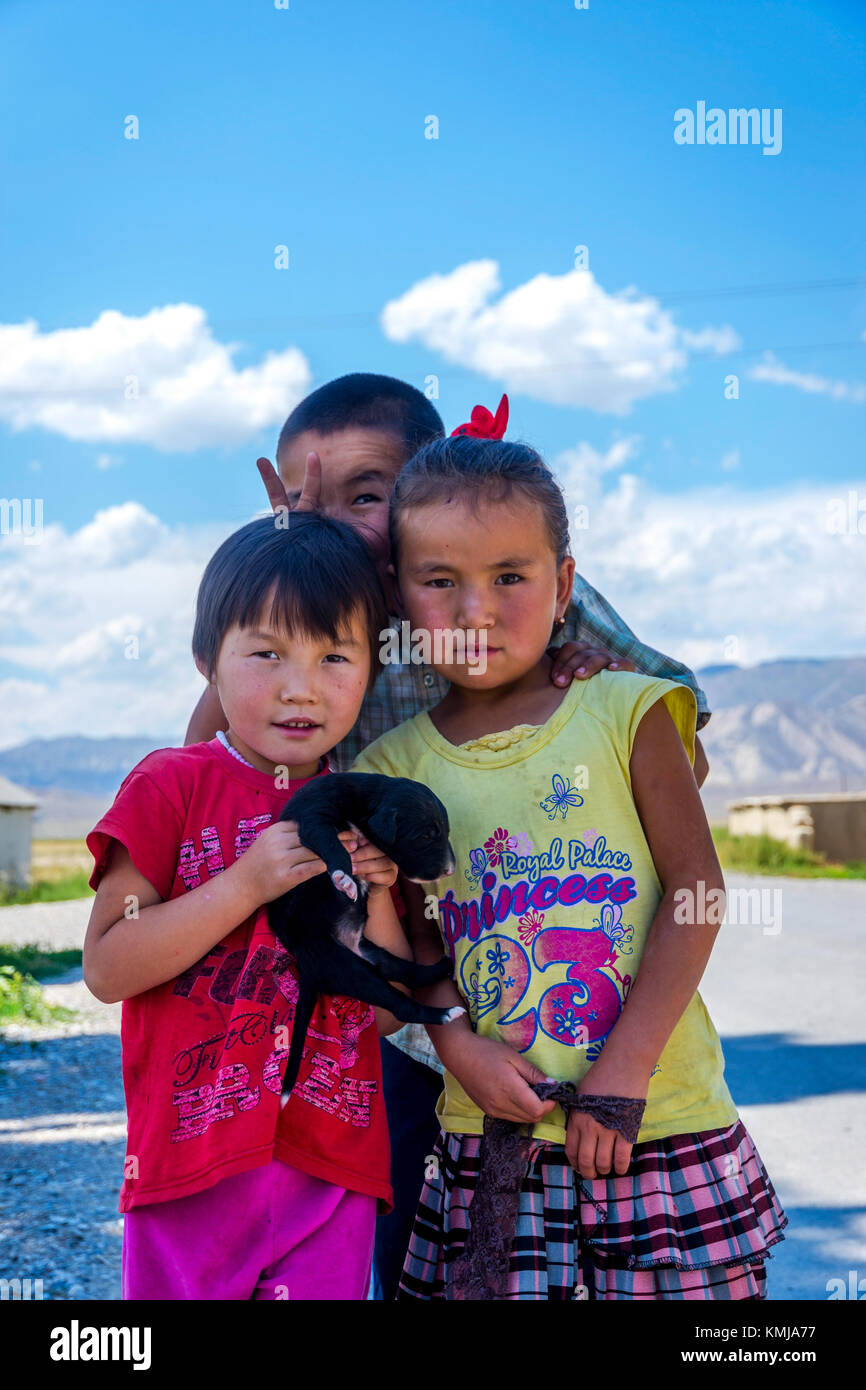 UGUT, KYRGYZSTAN - AUGUST 16: Local kyrgyz kids posing with a puppy in ...