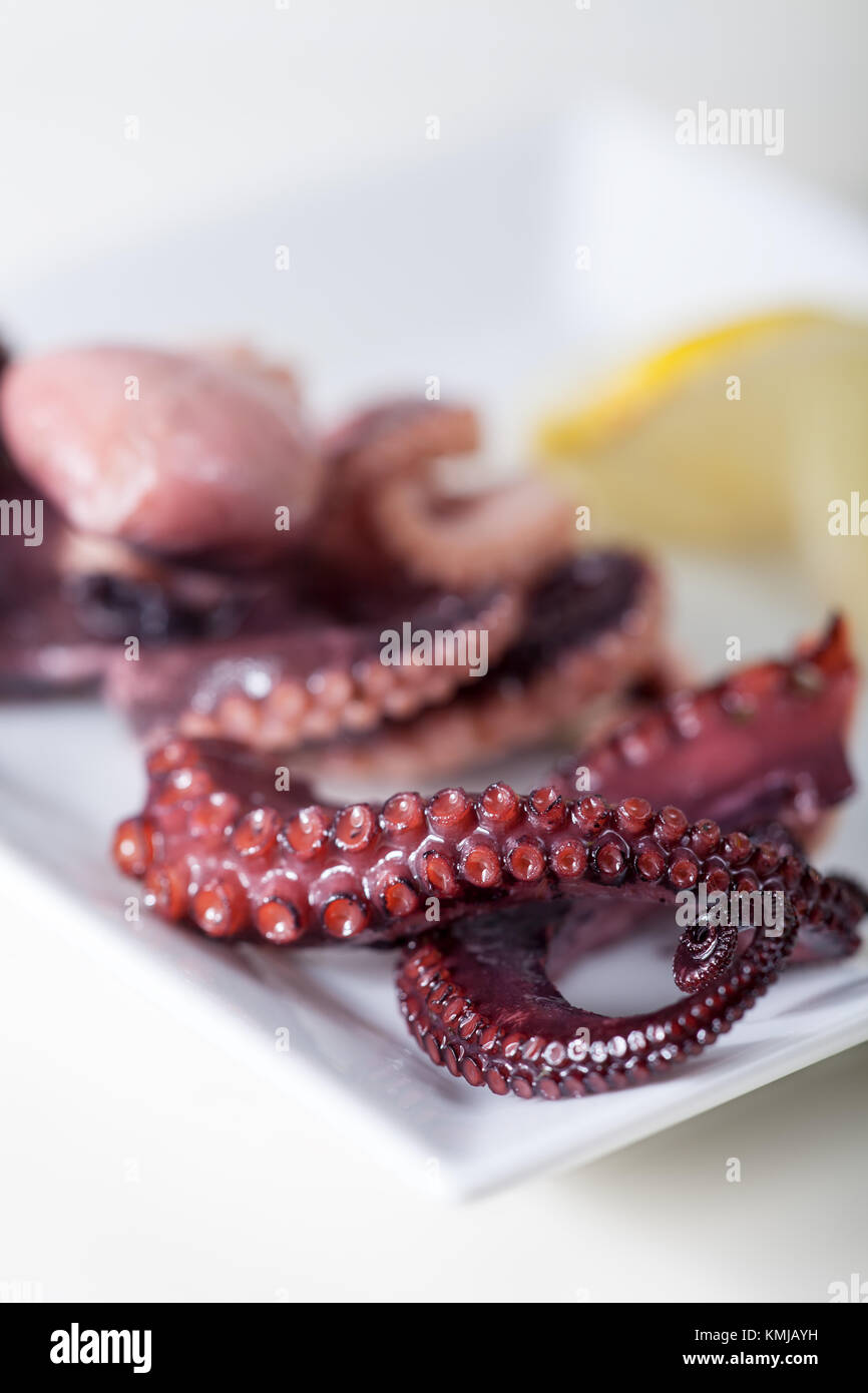 closeup of a octopus antipasti starter with a lemon Stock Photo - Alamy
